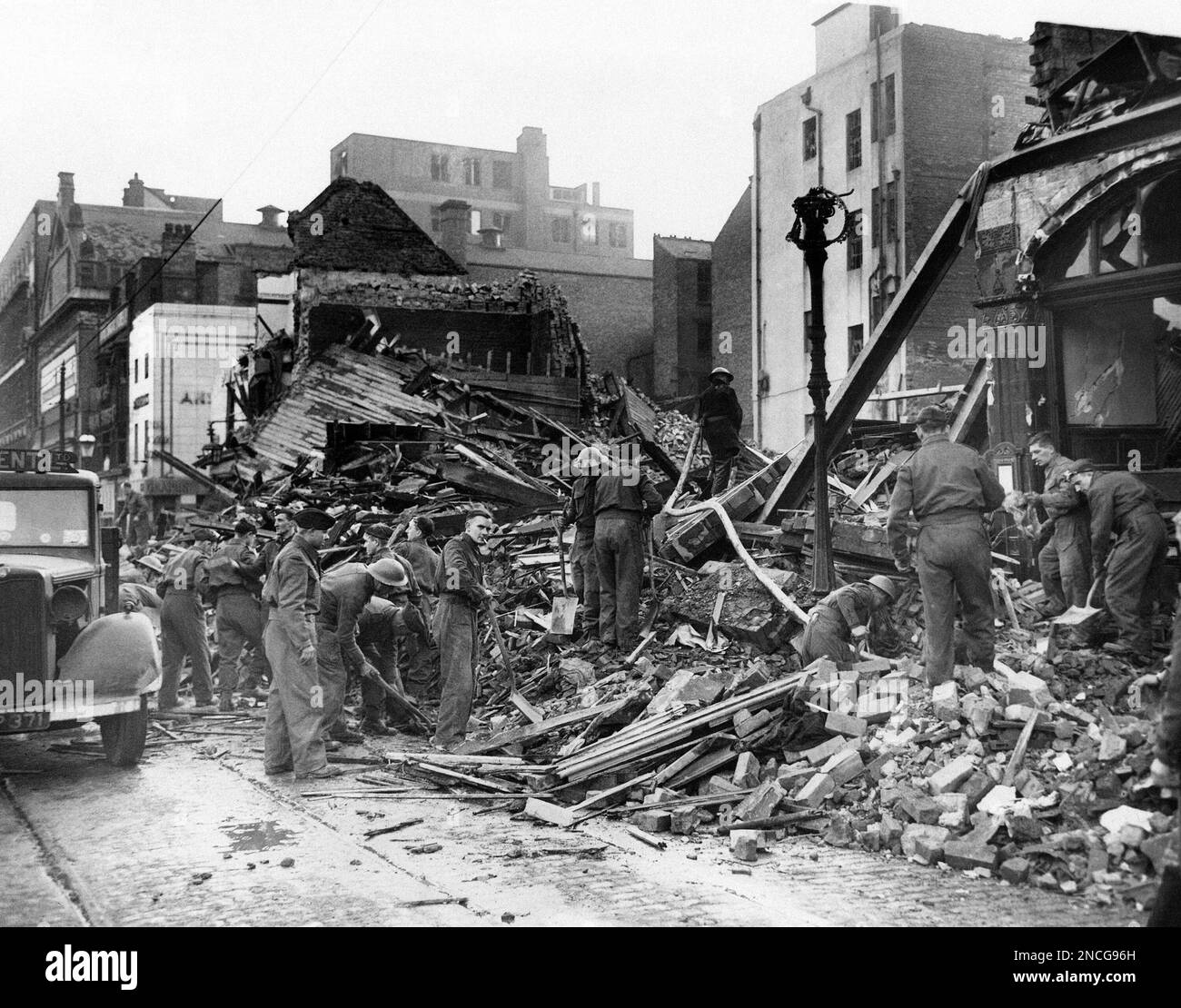 Soldiers of the shovel brigade clear up debris in the bombed streets of ...