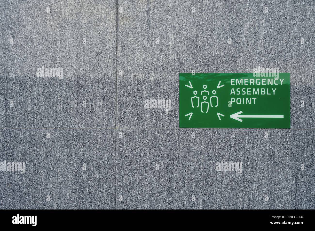 Emergency sssembly point sign on the textured wall with copy space ...