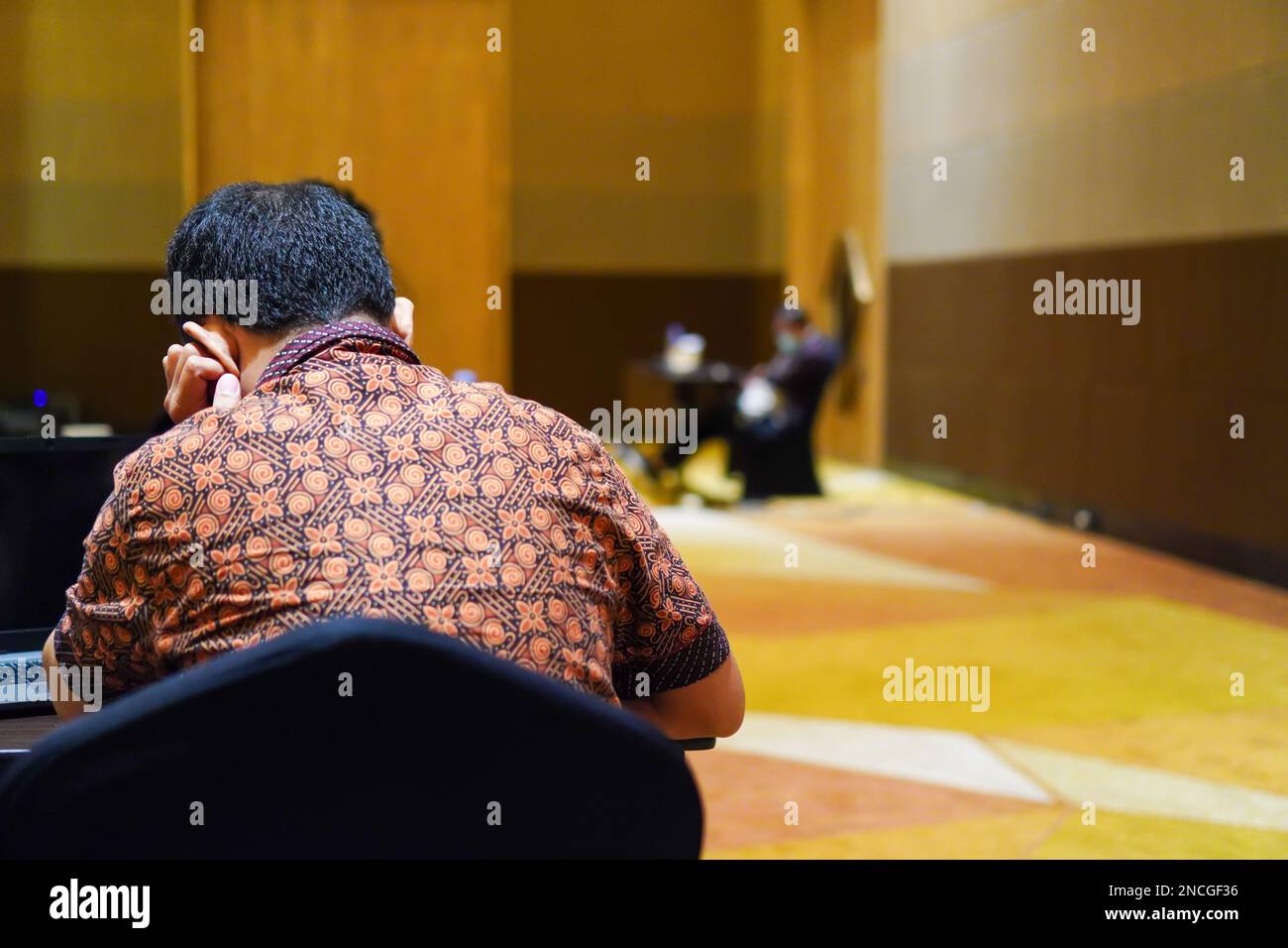 Male employee working in hall room with supervisor bokeh background ...