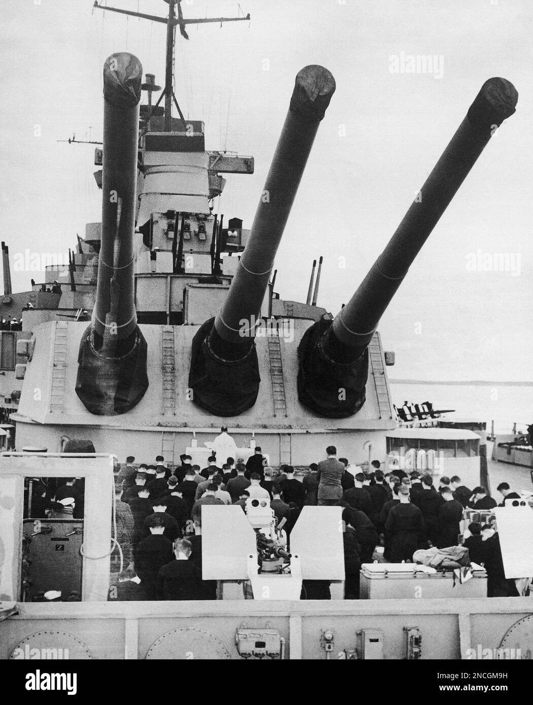 A catholic chaplain celebrates mass on the open deck of the battleship ...