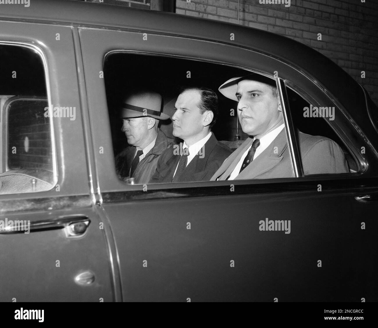 Seated in a police car between two officers, Dr. Samuel H. Sheppard was ...