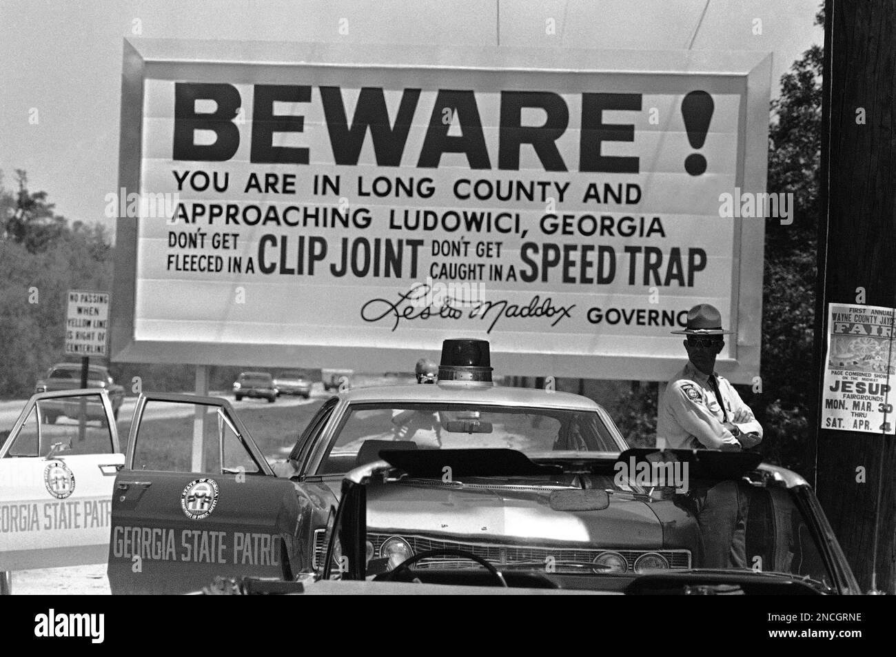 A Georgia State trooper stands guard over one of two signs ordered ...