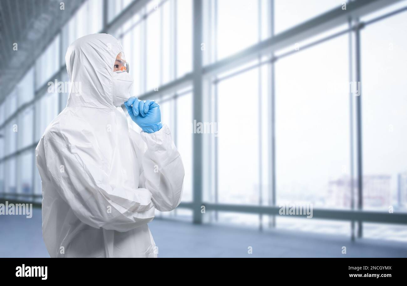 Worker wears medical protective suit or white coverall suit with mask ...