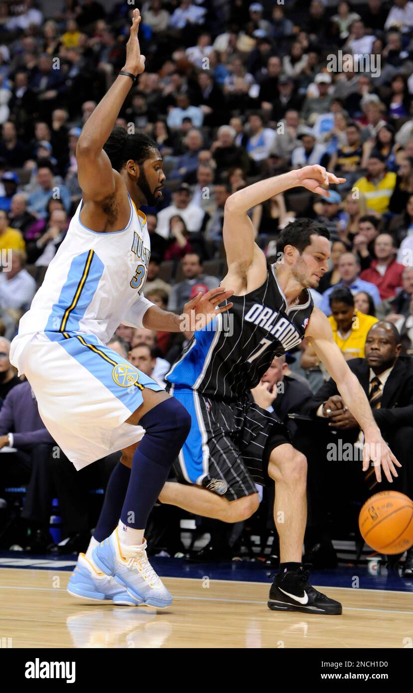 Denver Nuggets center Nene Hilario from Brazil pushes Orlando Magic guard J.J. Redick out of ...