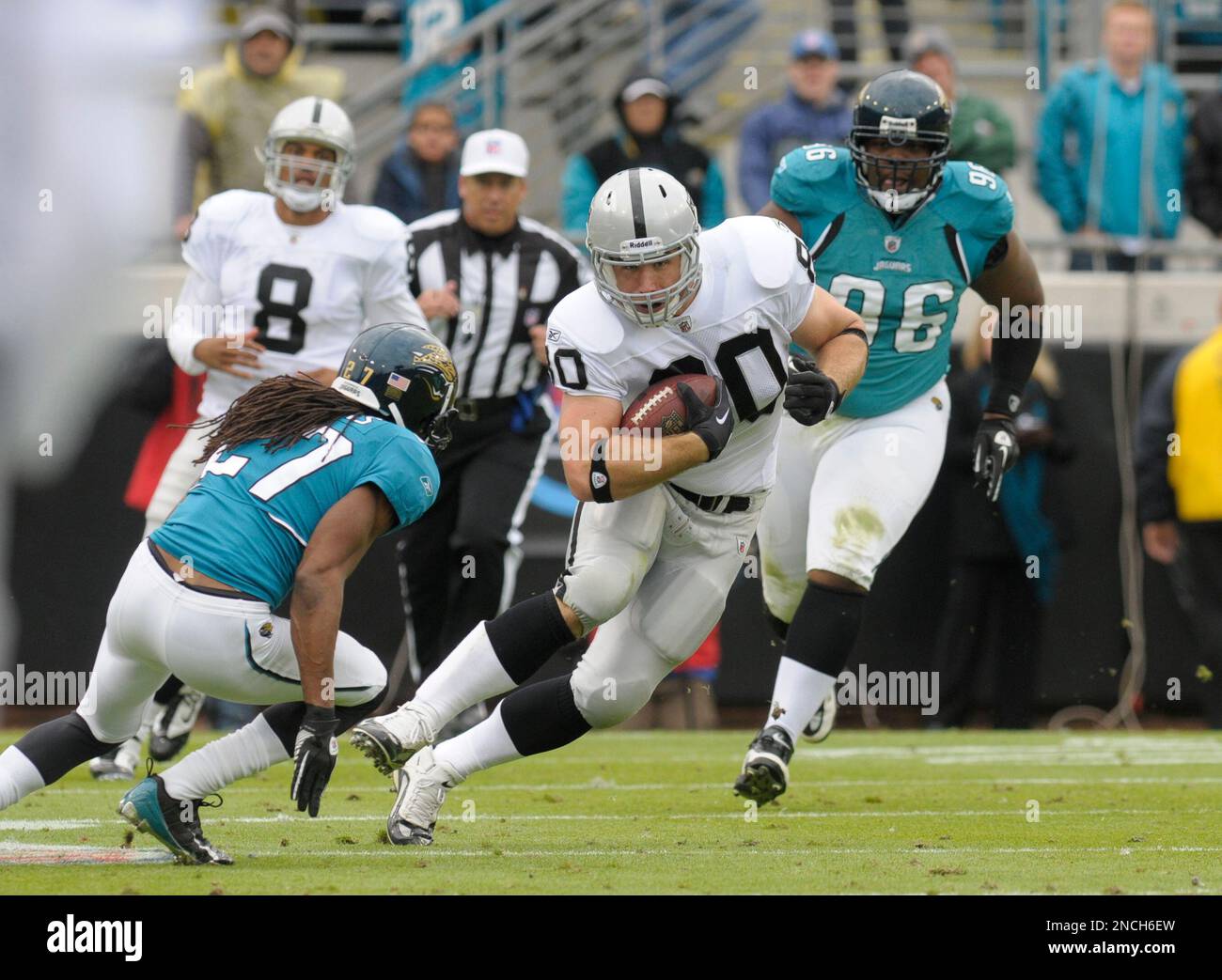Oakland Raiders tight end Zach Miller (80), center, is brought down by ...