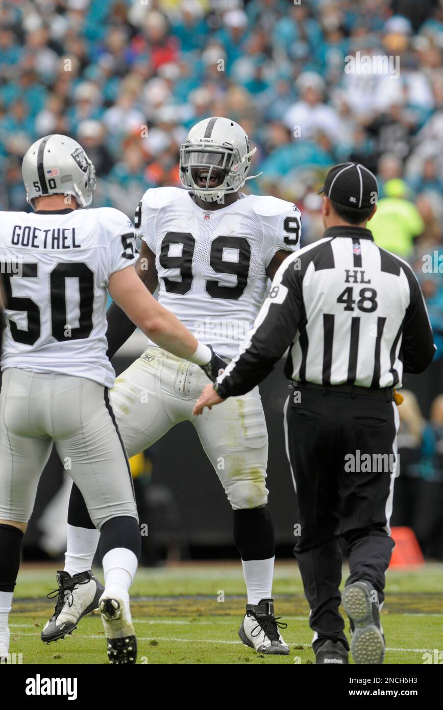 Oakland Raiders defensive end Lamarr Houston (99), center, and ...