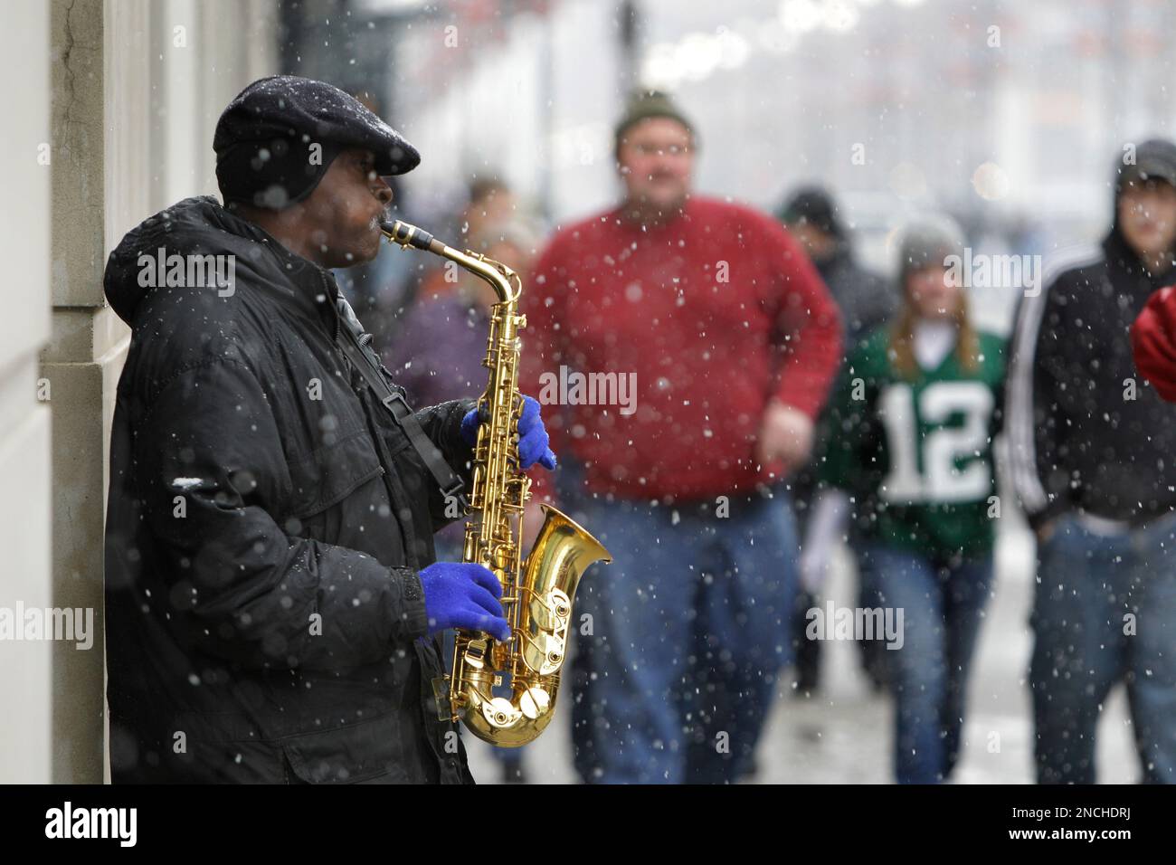 Street musician Jack Bostic plays his saxophone as fans head to Ford ...