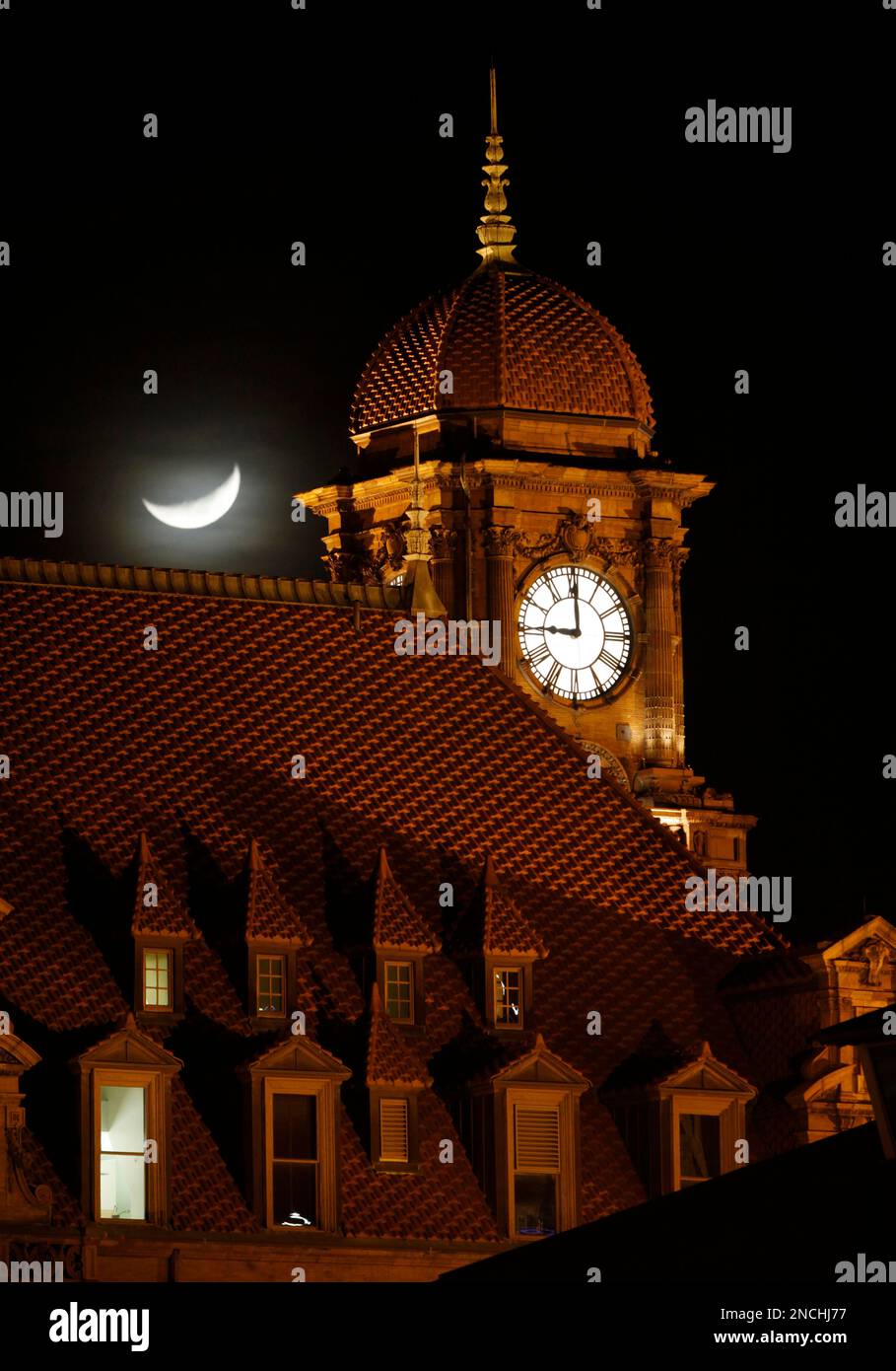 The moon sets behind the Main Street Station clock tower in downtown ...