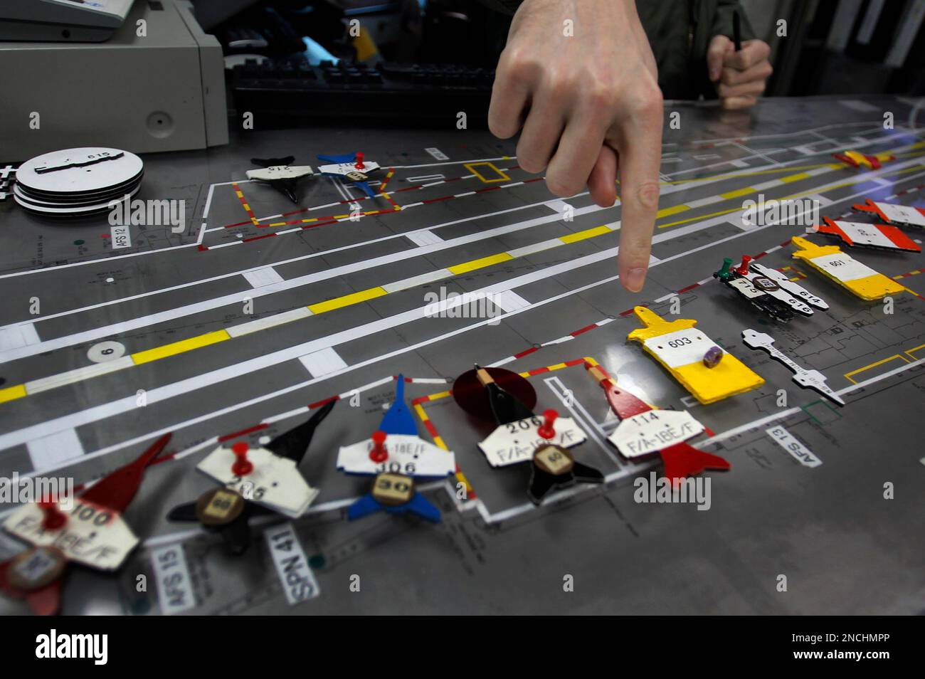 A US Navy aviation boatsman handler points their positions on a model ...