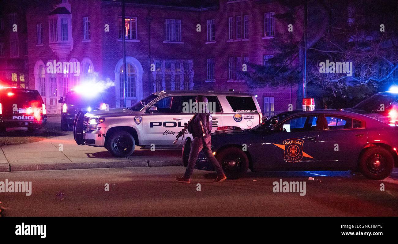 A police officer walks toward the Michigan State University campus with ...