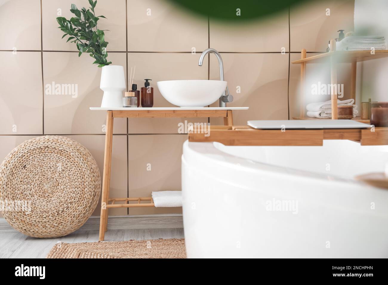 Interior of bathroom with modern bathtub, ceramic sink and laptop on ...