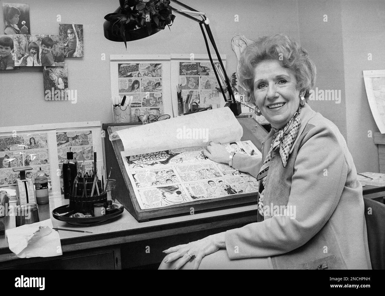 Dale Messick, creator of the comic strip "Brenda Starr, "looks up from ...