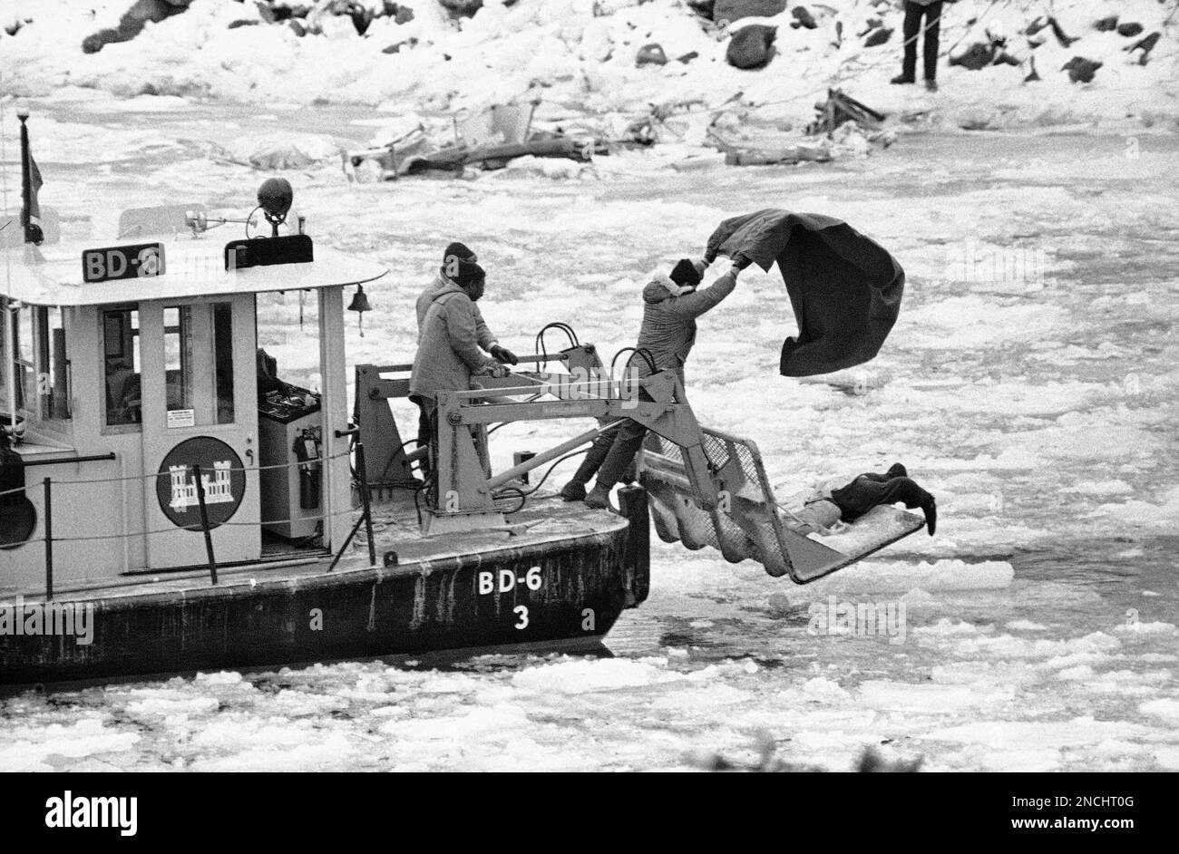 A recovery worker throws a blanket over a body in Washington, Monday ...