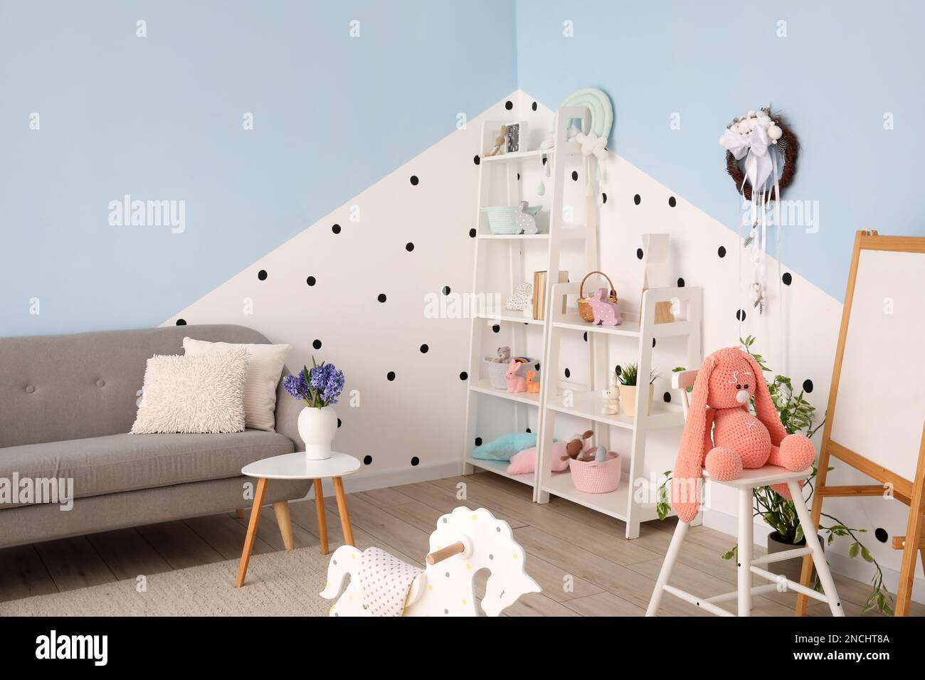 Interior of children's room with Easter wreath, shelving units and sofa ...