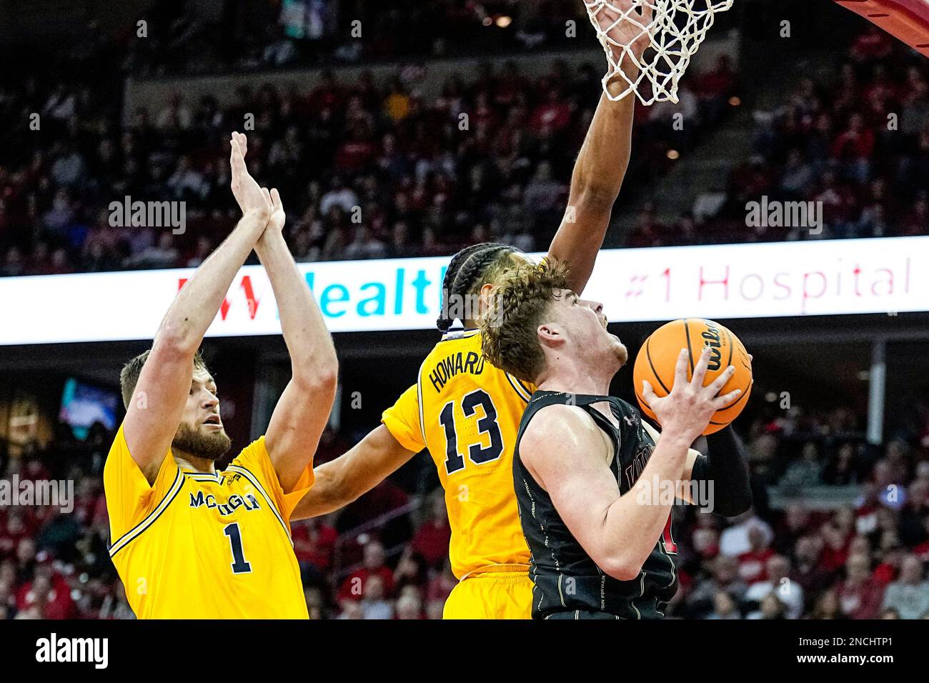 Wisconsin's Max Klesmit (11) shoots against Michigan's Hunter Dickinson ...