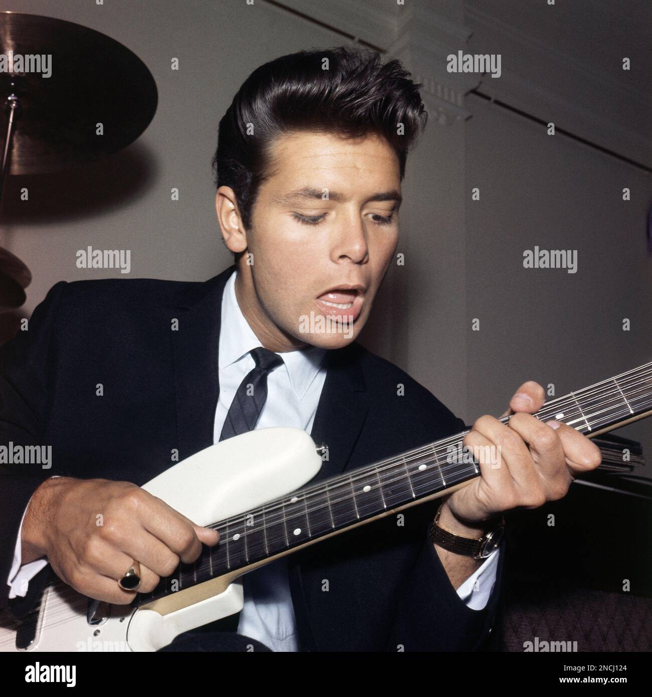 British pop singer Cliff Richard plays a guitar and sings, pictured ...