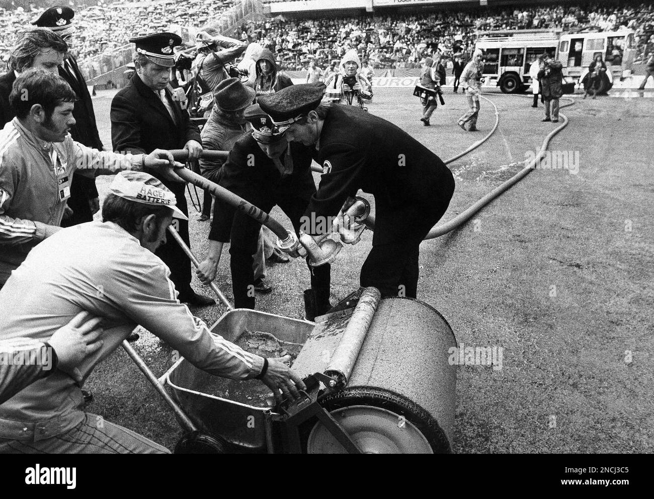 Firefighters pump the water away from the soccer field after heavy ...