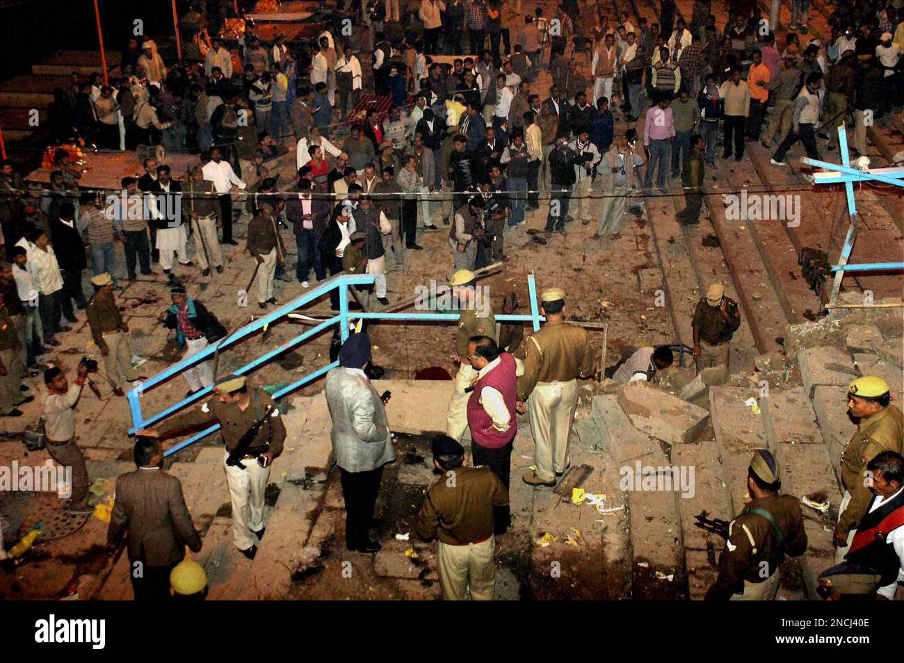 People watch as policemen and officials inspect the site of an ...