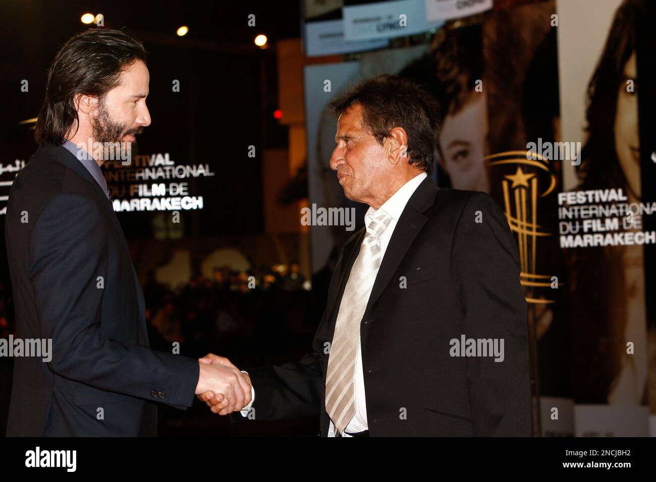 Canadian actor Keanu Reeves, left, shakes hands with Moroccan-born ...