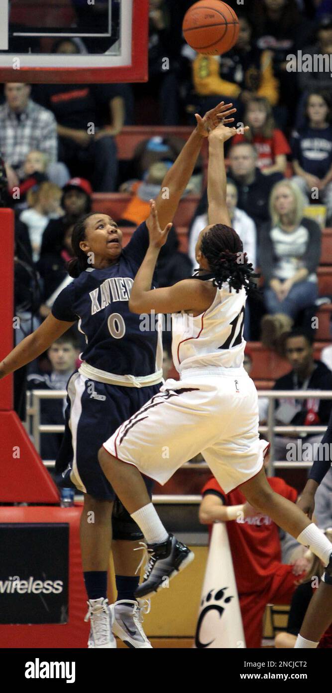 Xavier's Tyeasha Moss, left, blocks a shot-attempt by Cincinnati's ...