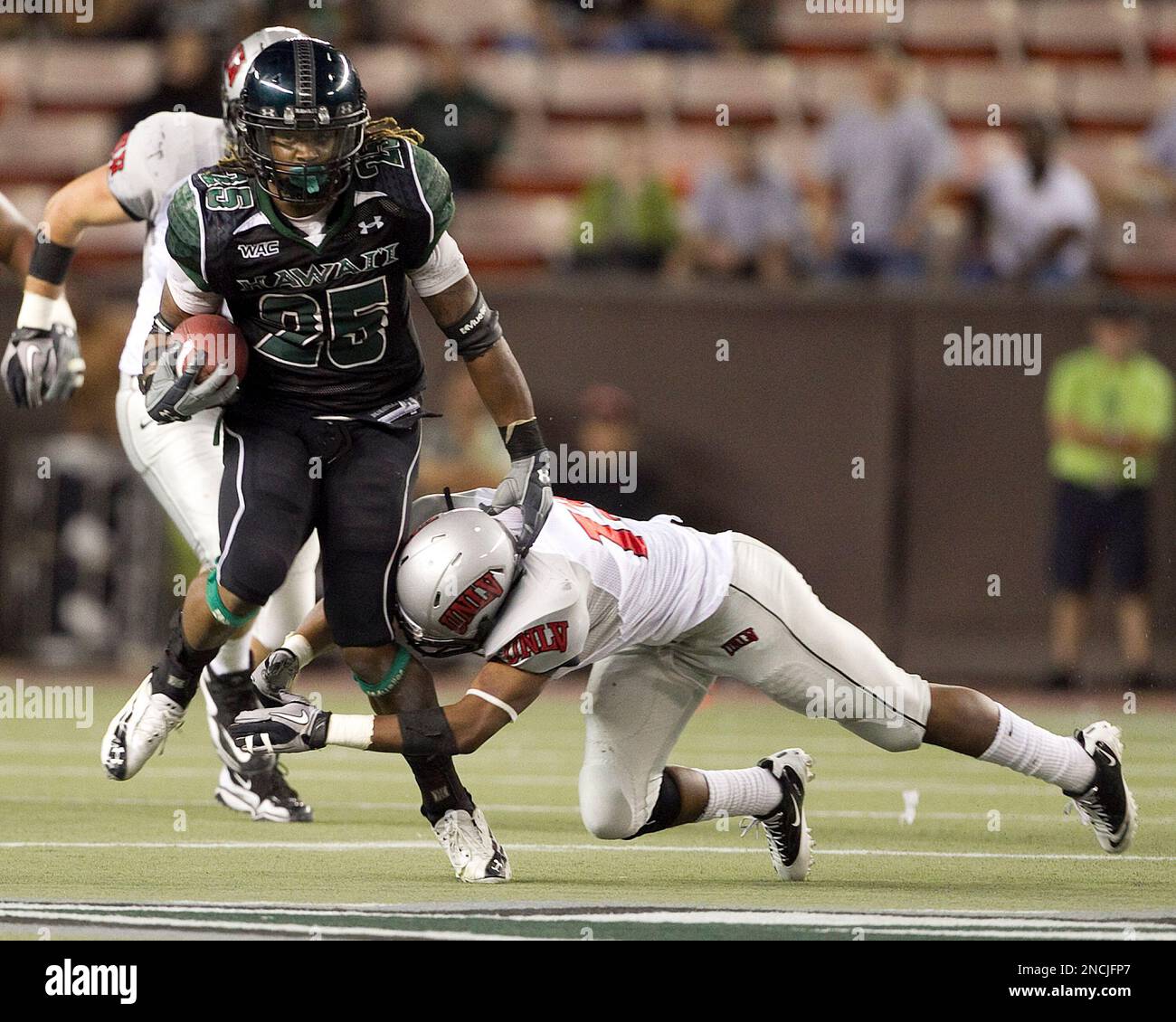 Hawaii running back Alex Green runs past UNLV defensive back Eric ...