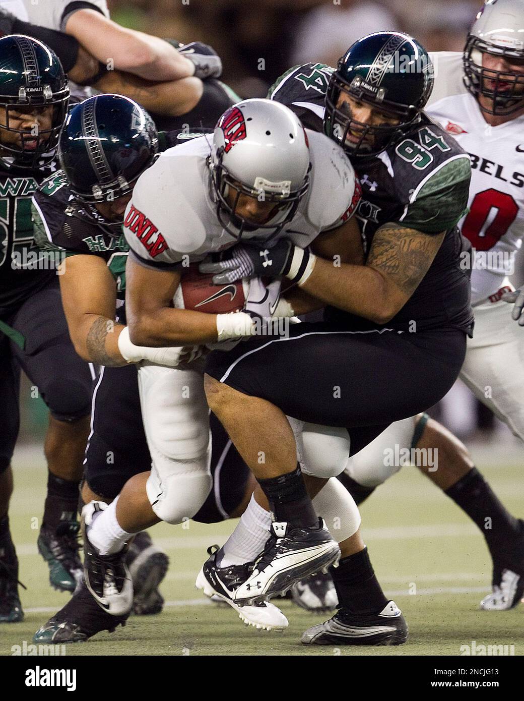 UNLV running back Tim Cornett, center, is stopped by the Hawaii ...