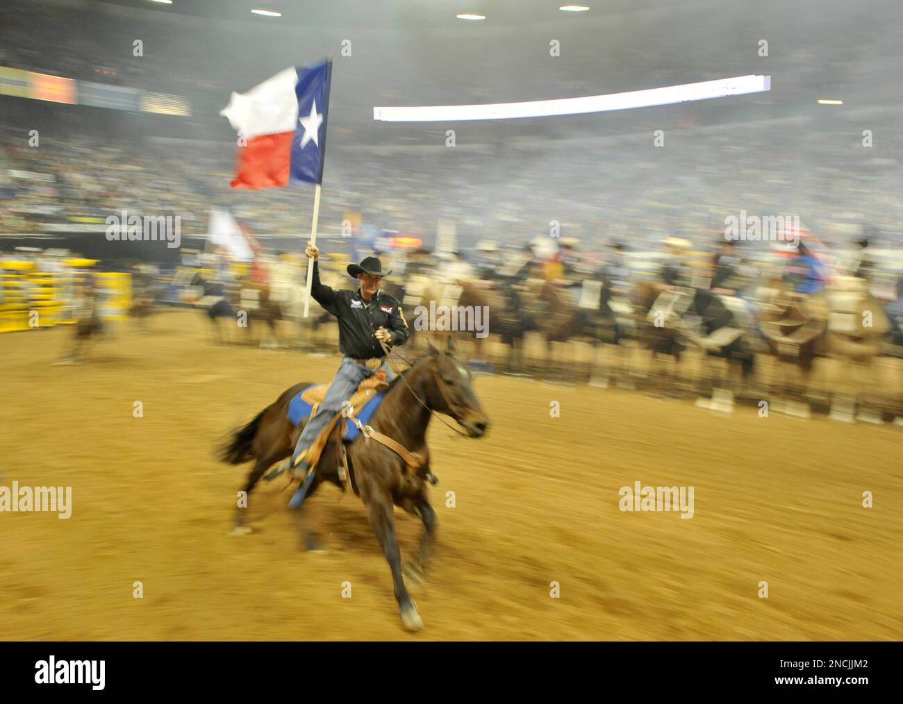 Cowboys enter the arena with flag-waving fanfare during the second go ...