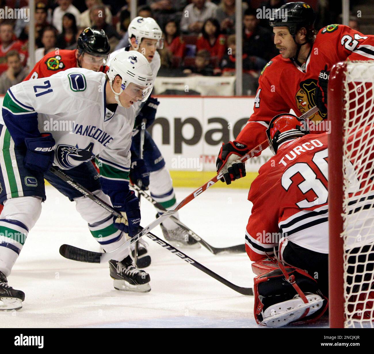 Vancouver Canucks' Mason Raymond, left, shoots against Chicago ...