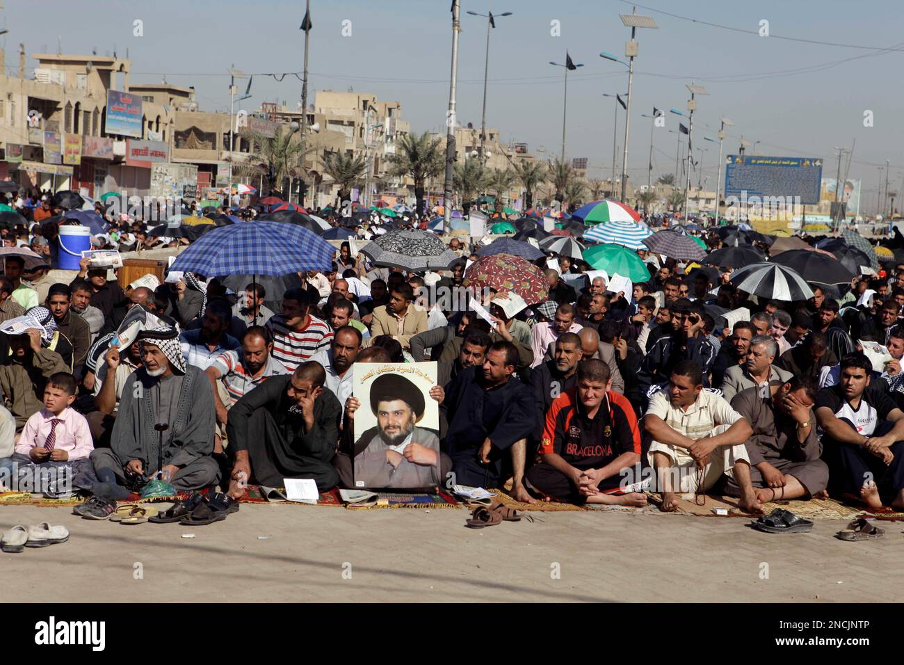 Followers of radical Shiite cleric Muqtada al-Sadr, seen in the poster ...