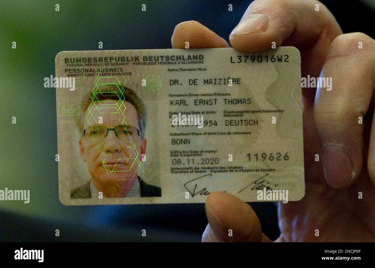 German Interior Minister Thomas de Maiziere shows his new ID card in ...