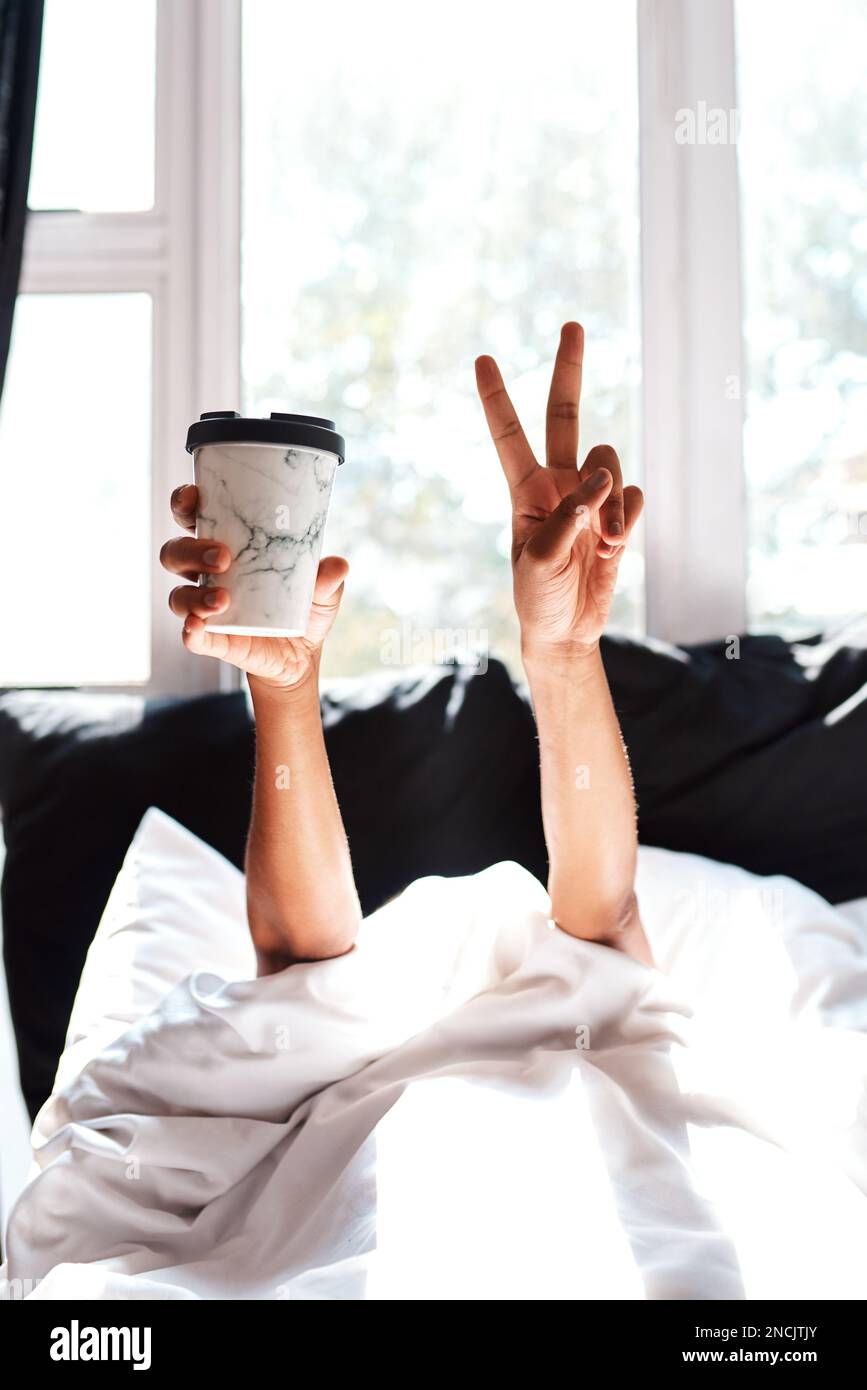 Coffee makes me less grumpy when I wake up. a woman lying in the covers ...