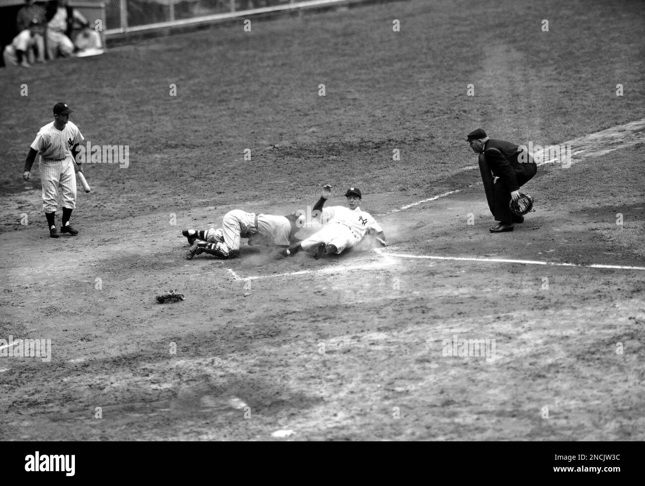 Joe DiMaggio, New York Yankee outfielder, slides safely across home ...