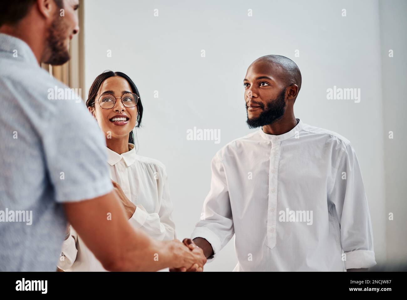 Congratulations on your promotion. two young businessmen shaking hands ...