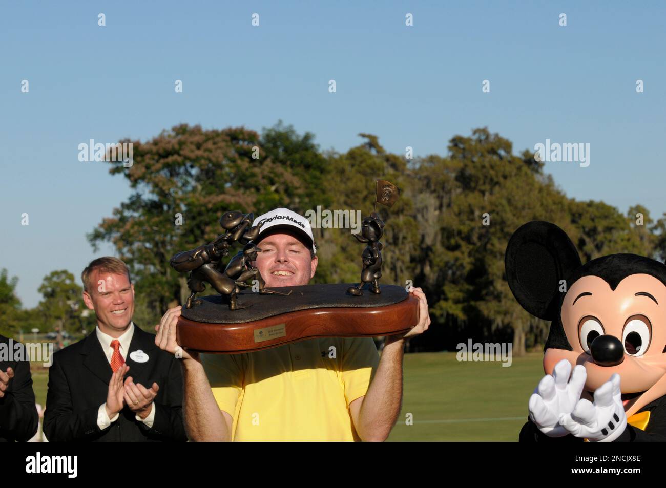 Robert Garrigus, center, hoists the championship trophy, with Mickey ...