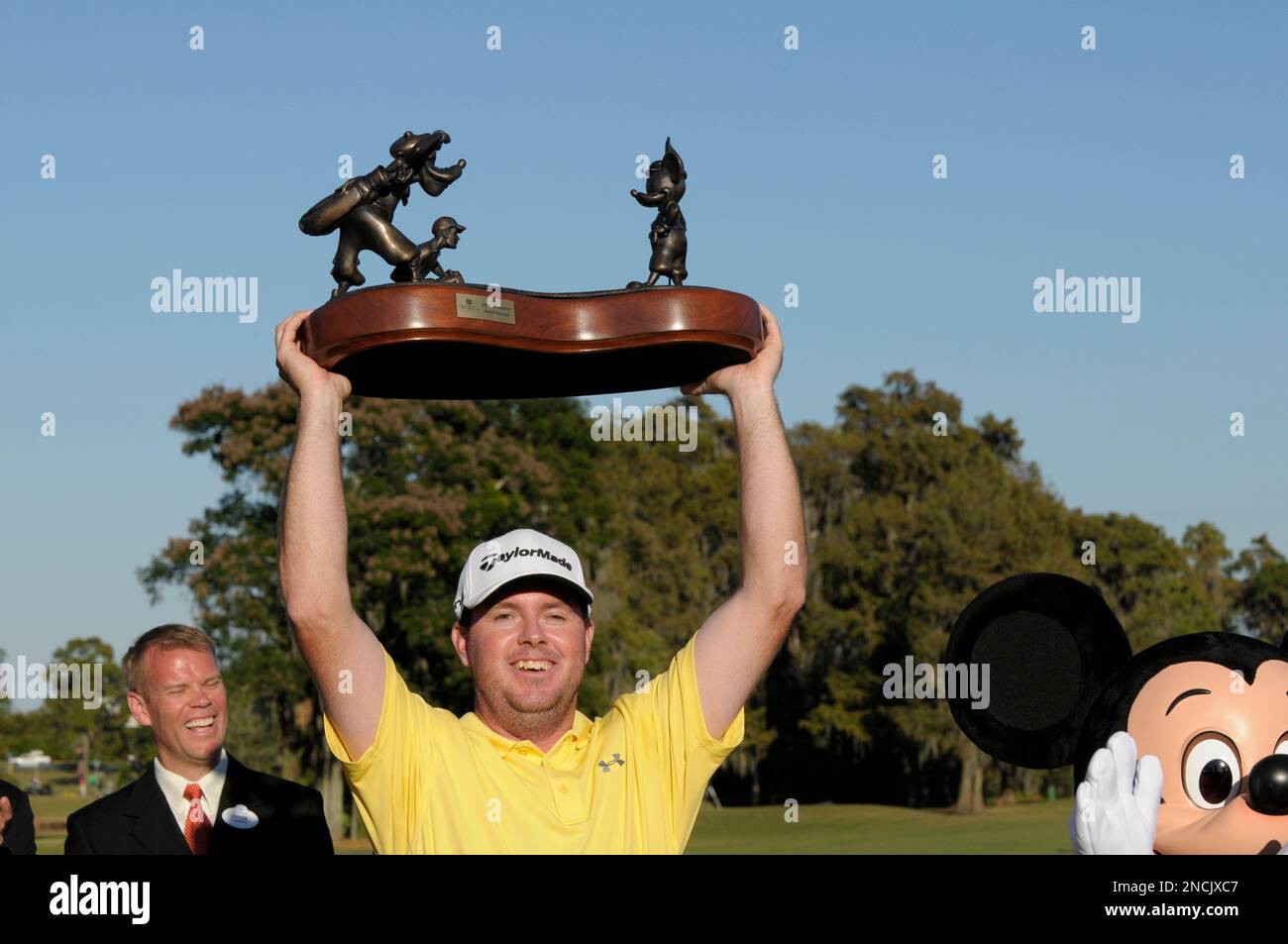 Robert Garrigus, center, hoists the championship trophy, with Mickey ...