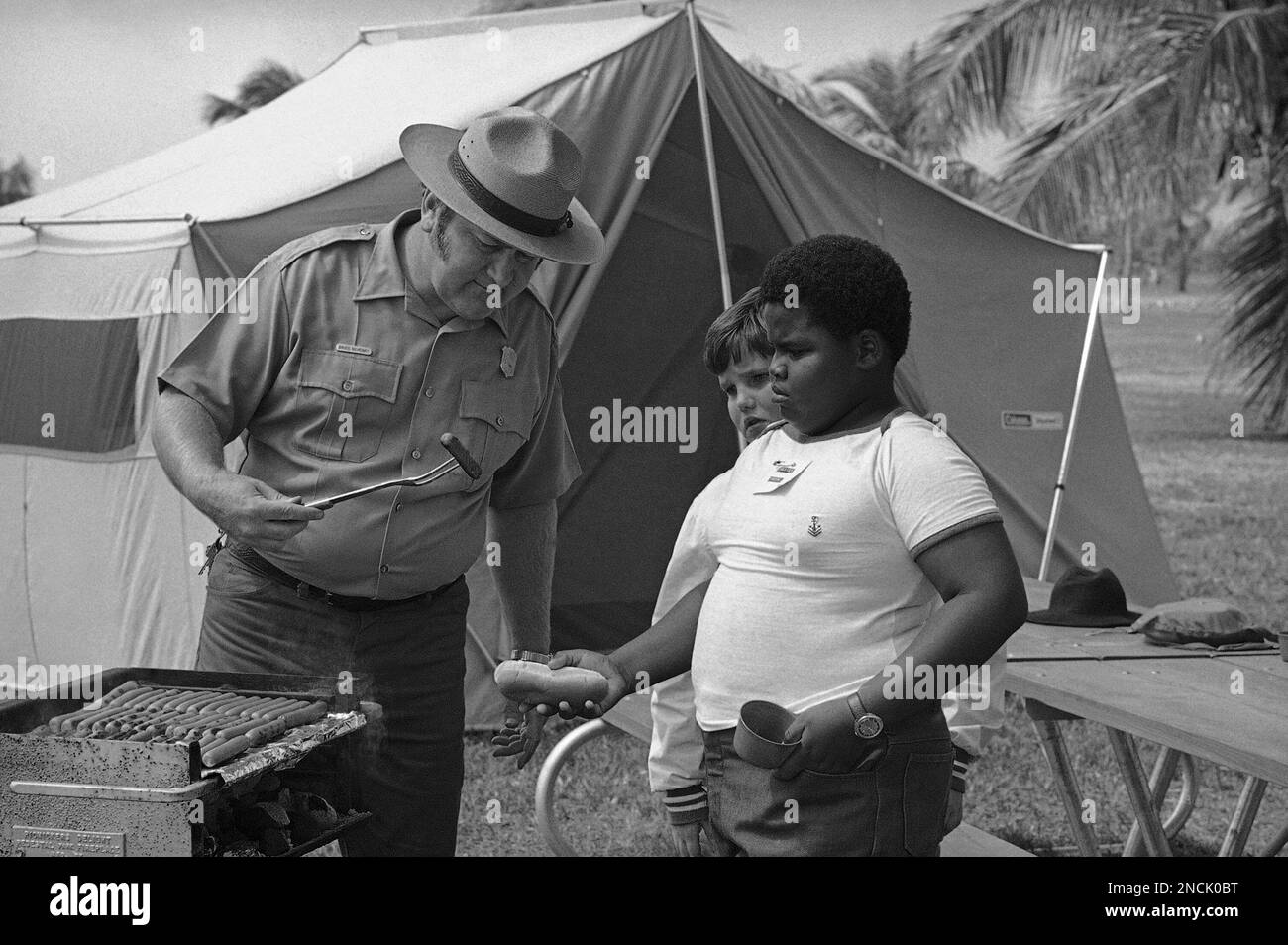 Park ranger Bruce McHenry offers a hot dog to Xavier Moore, 11, a fifth grader at Hialeah's ...