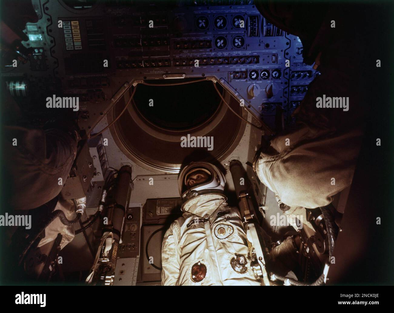 Two suited-up men lie on their couches inside the command module just ...