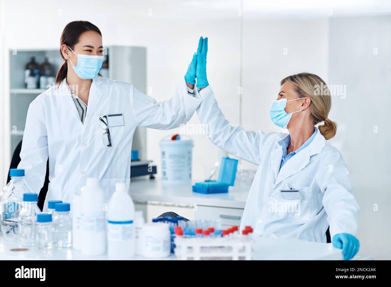 Well make medical history together. two scientists giving each other a high five in a lab Stock ...
