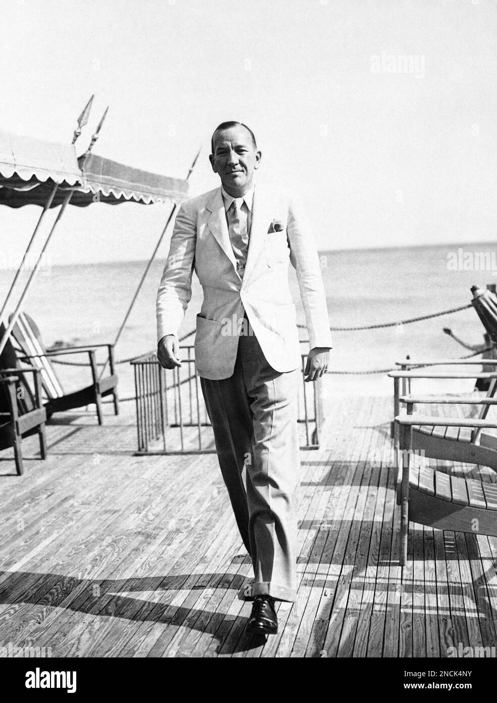 Noel Coward, British playwright and composer, strolls on the boardwalks ...