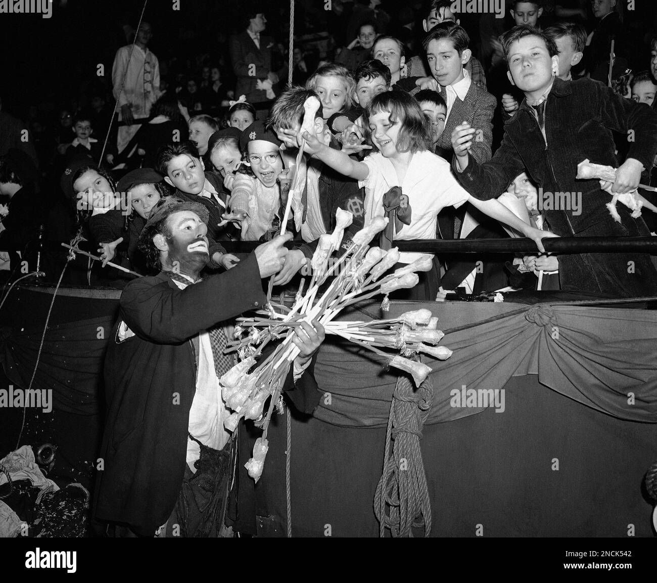 Emmett Kelly, famous clown, hands out canes to impatient youngsters at ...