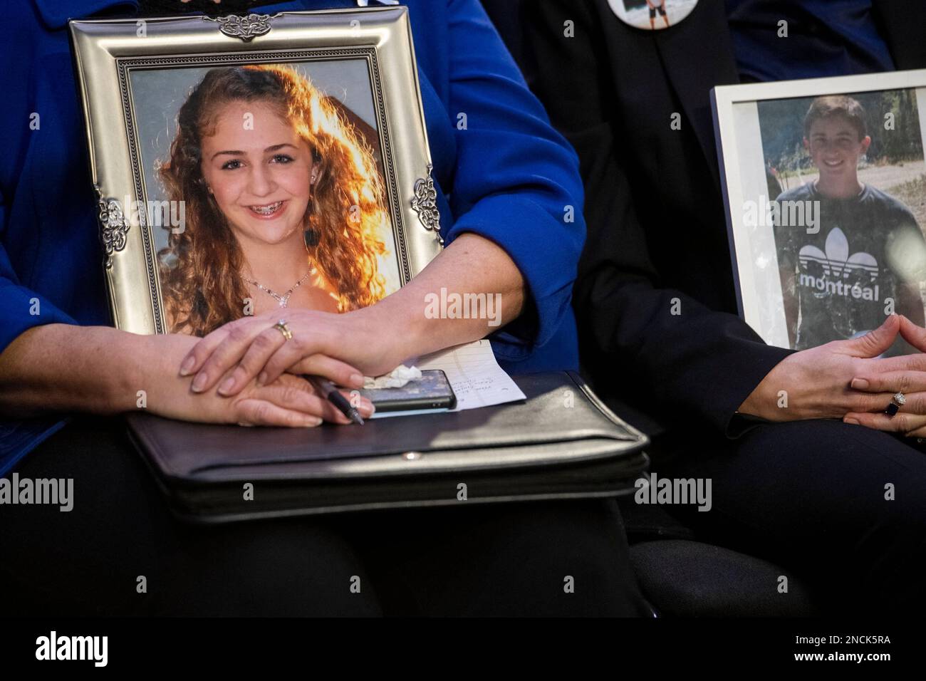 Christine McComas, left, holds a photo of her daughter Grace McComas ...