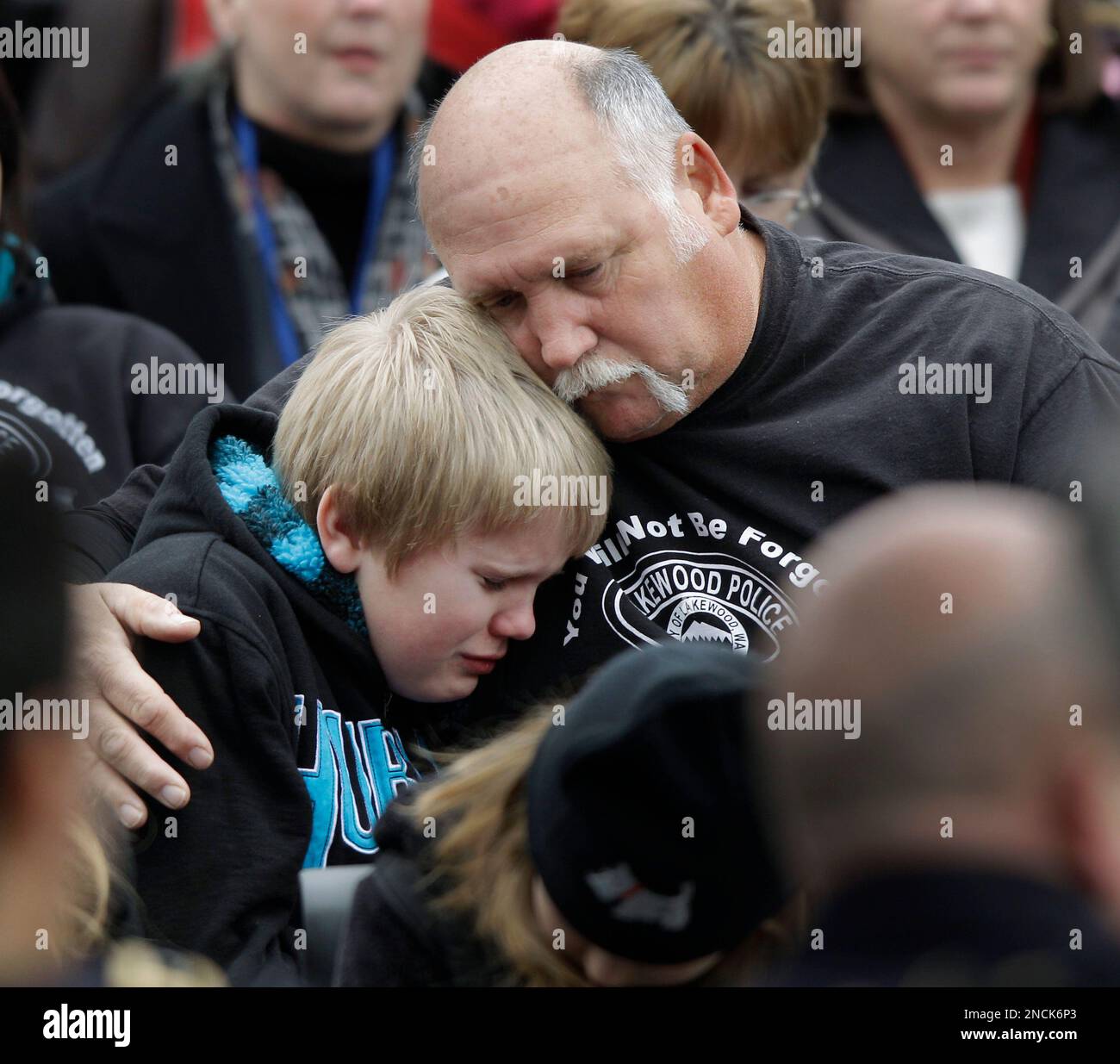 An unidentified man comforts Gavin Richards, left, the son of slain ...