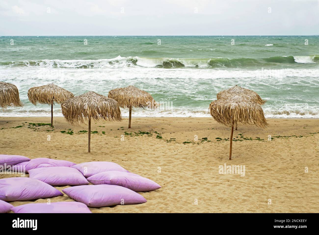 Bad weather. Deserted beach. Empty sun loungers next to the stormy sea ...