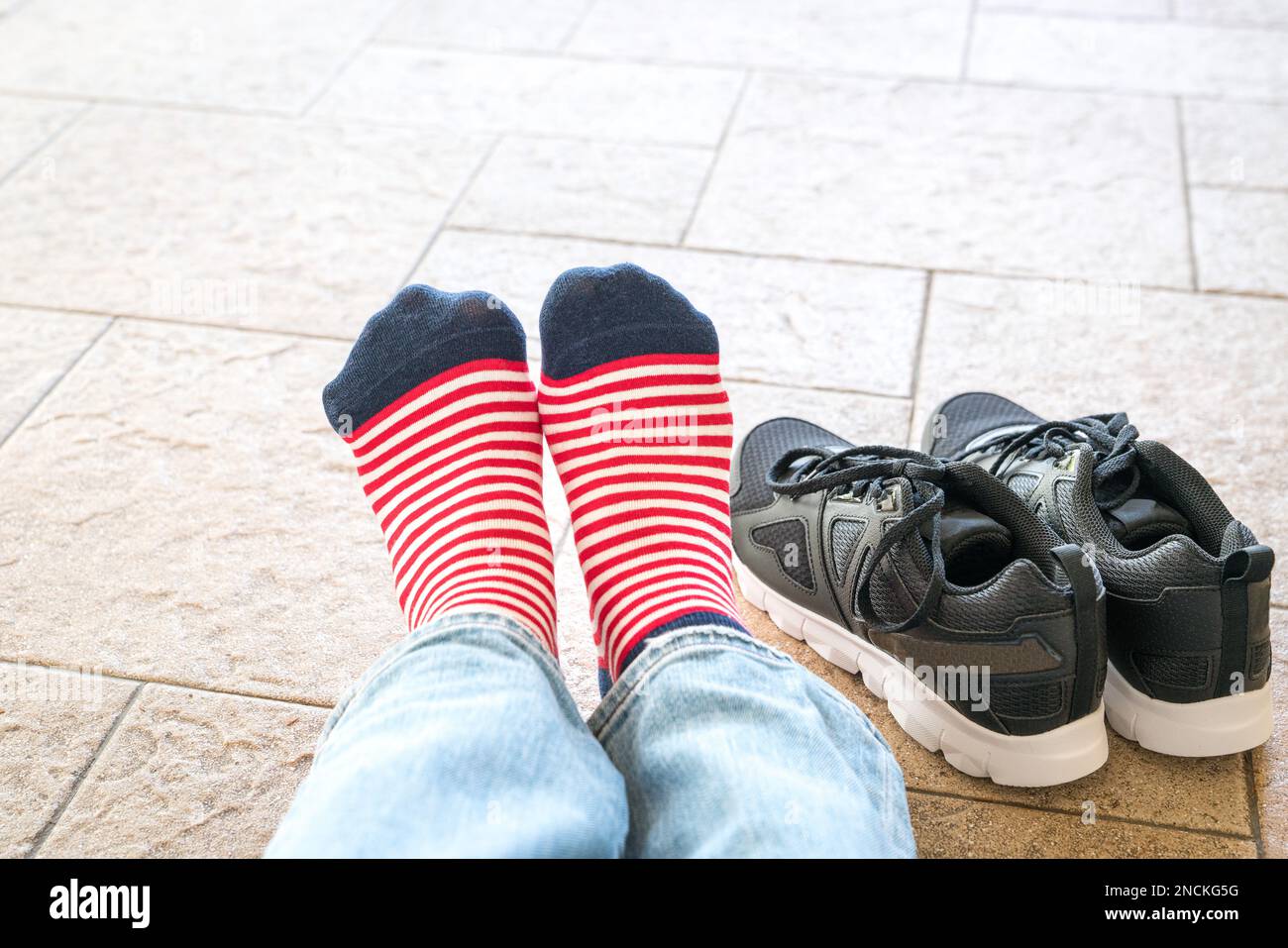 Woman's feet with colorful socks and sport shoes by the side, close up ...