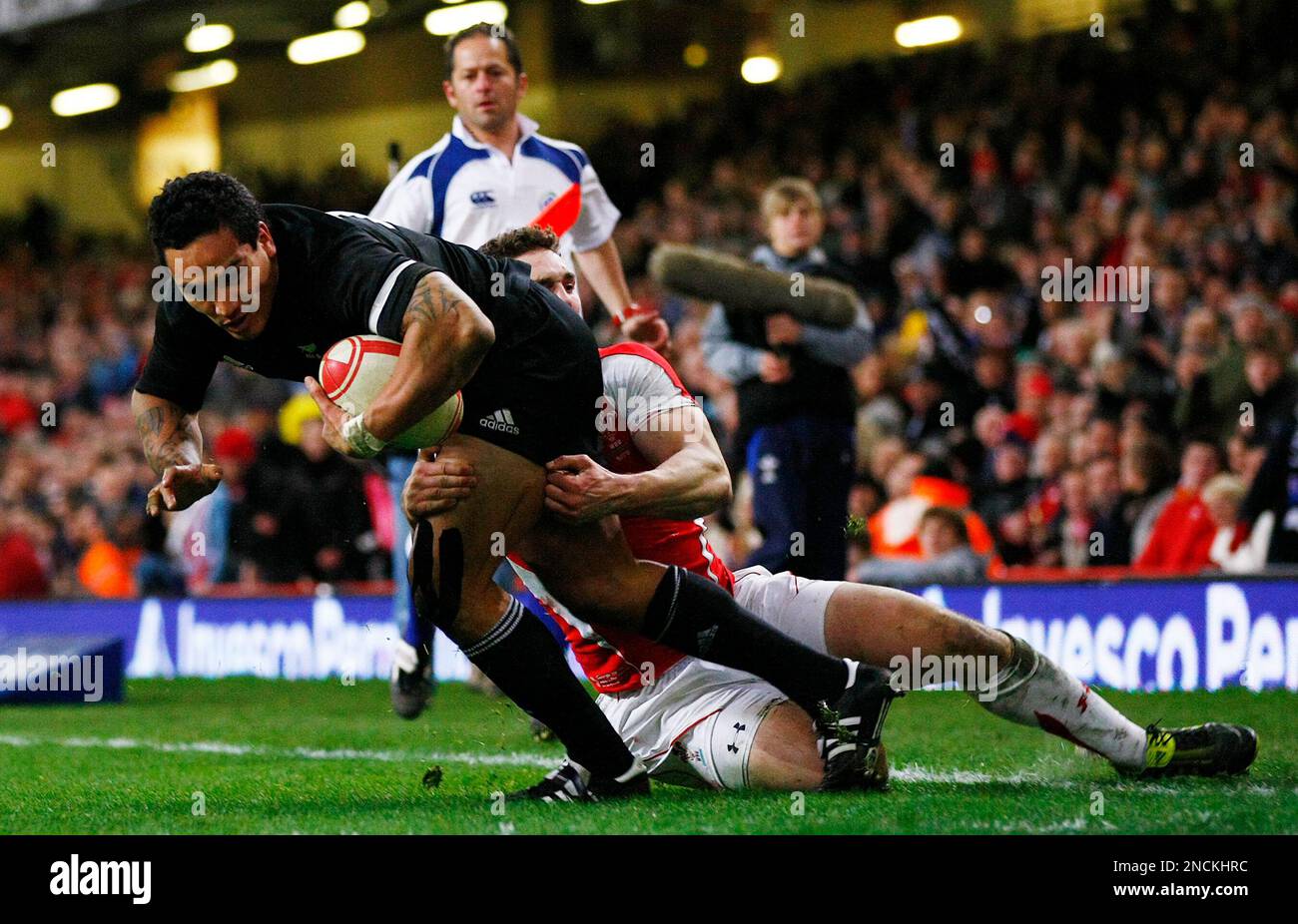 New Zealand's Hosea Gear, left, dives over in the tackle of Wales ...