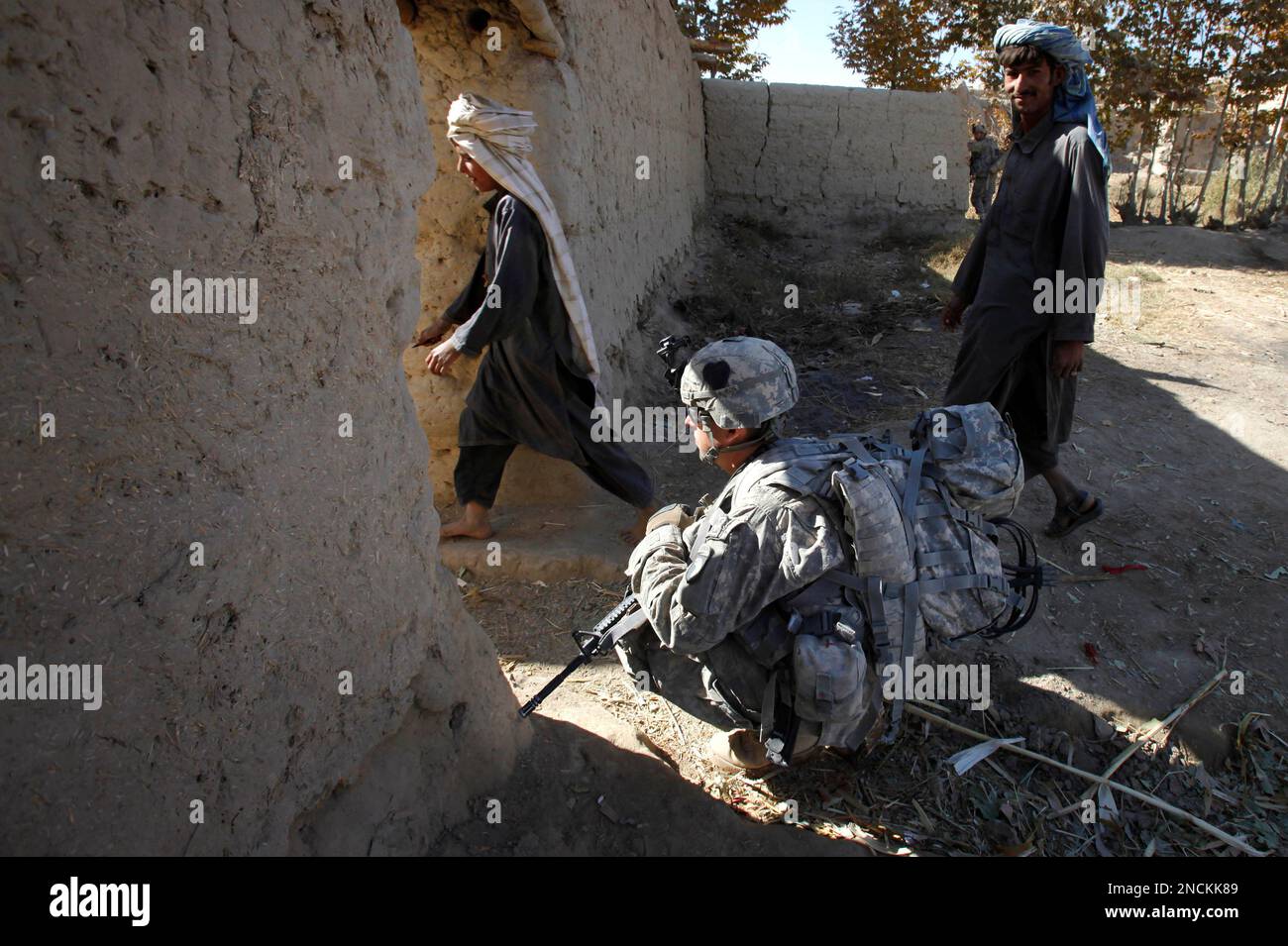 Afghanis passe a U.S. Army soldier from First Battalion, 502nd Infantry ...