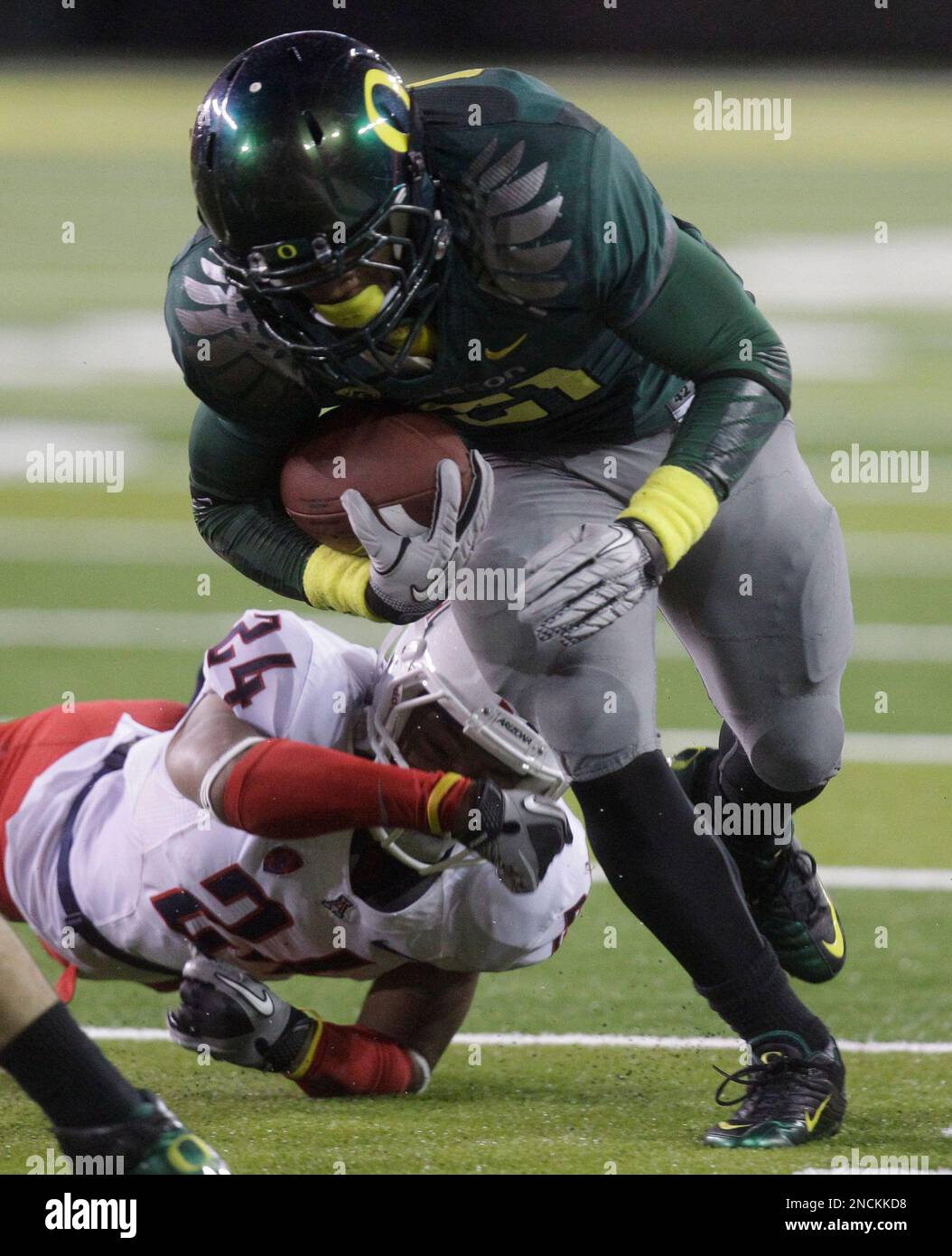 Oregon running back LaMichael James (21) runs over Arizona cornerback ...