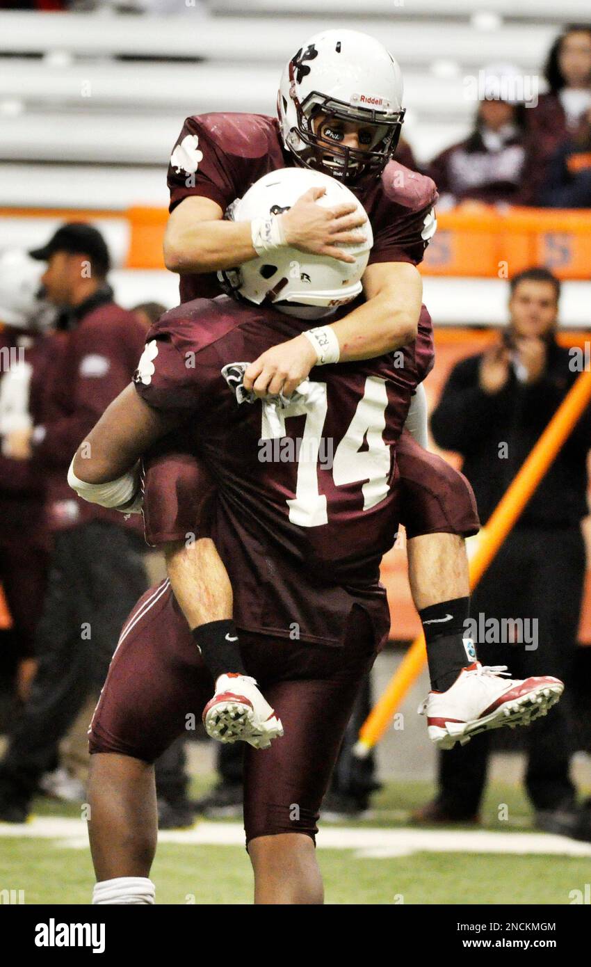 Aquinas' Mike Messina jumps into the arms of Jarron Jones (74) after ...
