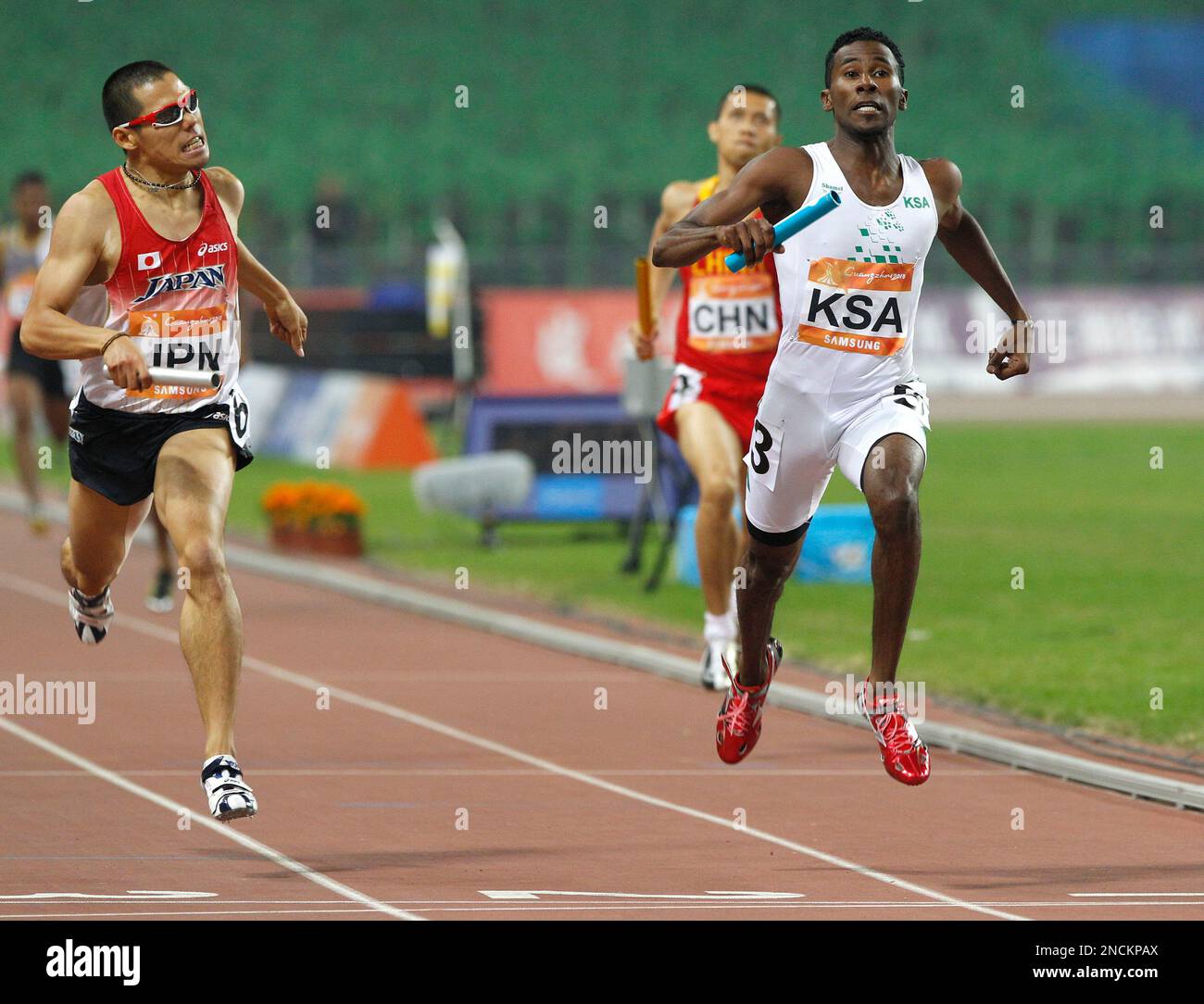 Saudi Arabia's Yousef Ahmed M Masrahi, right, sprints ahead of Japan's ...