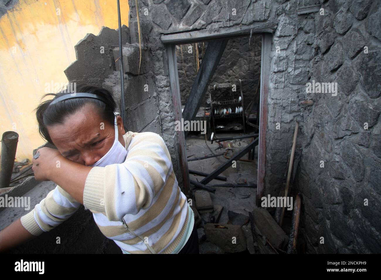 Resident Sukitri weeps after seeing her house destroyed by the eruption ...